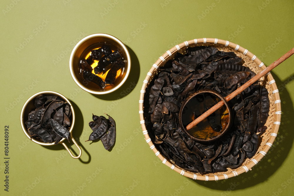 Over green background, black locust fruits are contained inside a ...