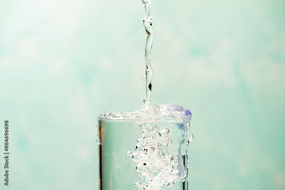 Splash in a glass, drop of water falling into a transparent glass ...