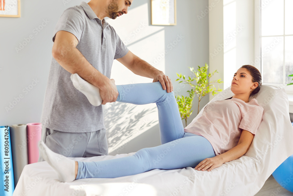 Physiotherapist treats leg injury and helps patient perform exercises ...