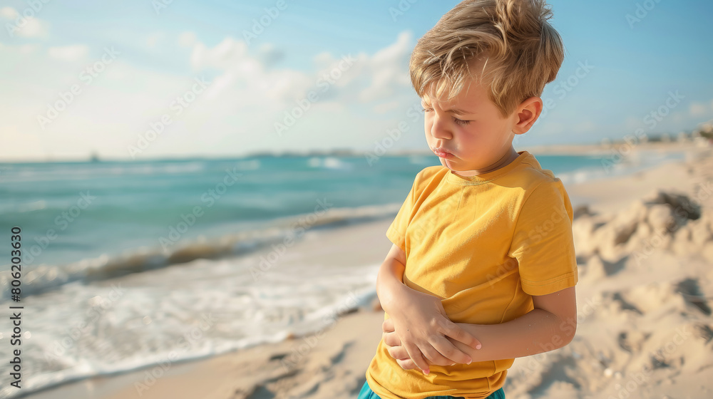 Foto de Stock upset boy holding his sore stomach on the beach, diarrhea ...
