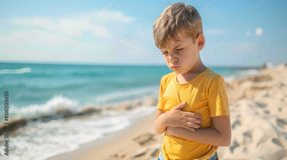 Stock-Foto „upset boy holding his sore stomach on the beach, diarrhea ...