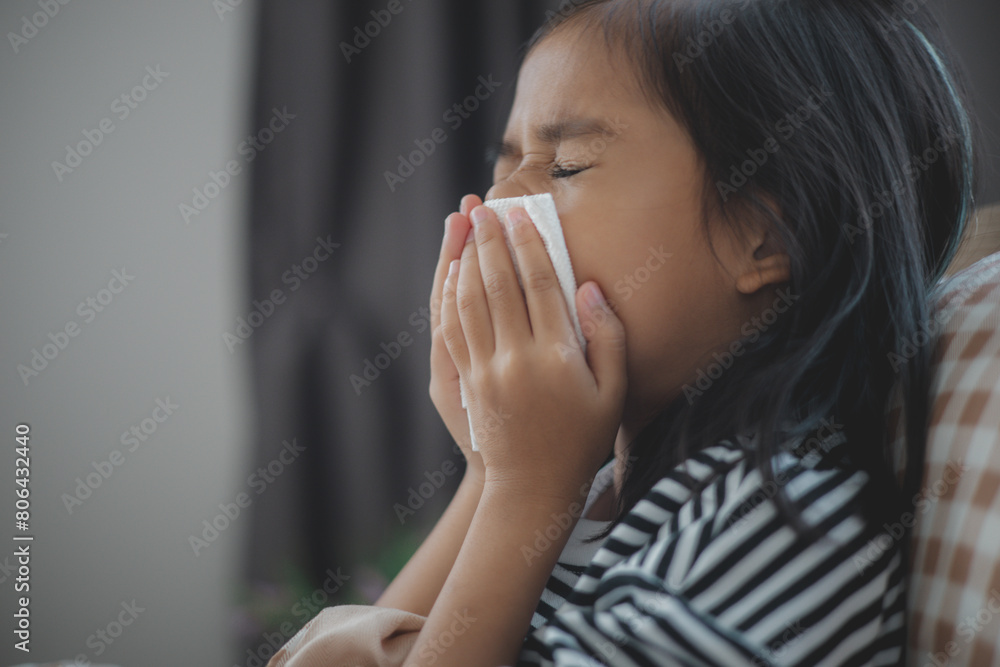Sick Asian girls have high fevers and flu and sneeze into tissues in bed in the bedroom ...