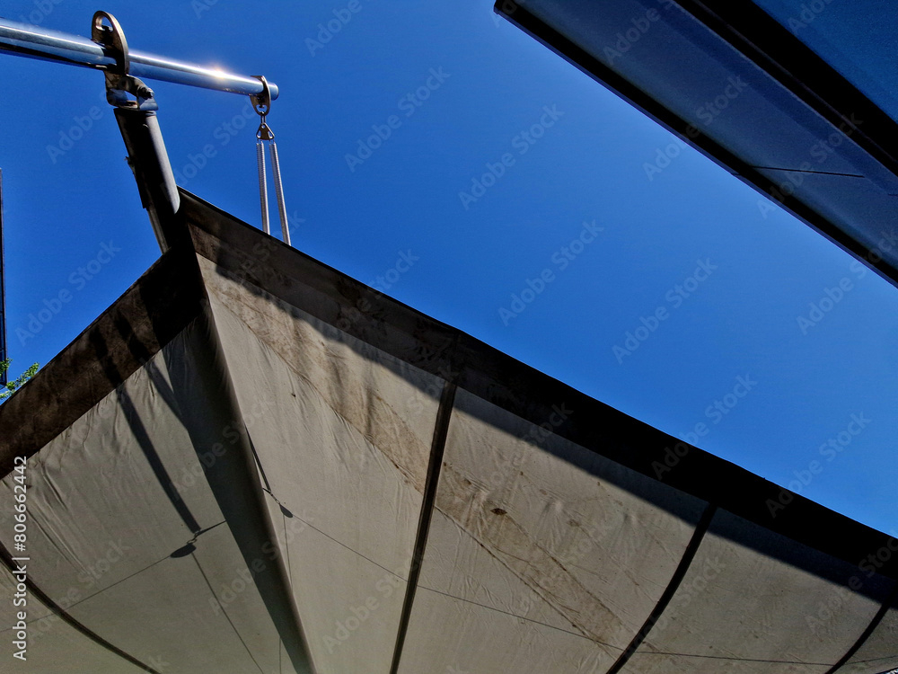 parasol, awning, folding tarpaulin against the sun is rolled up into a ...