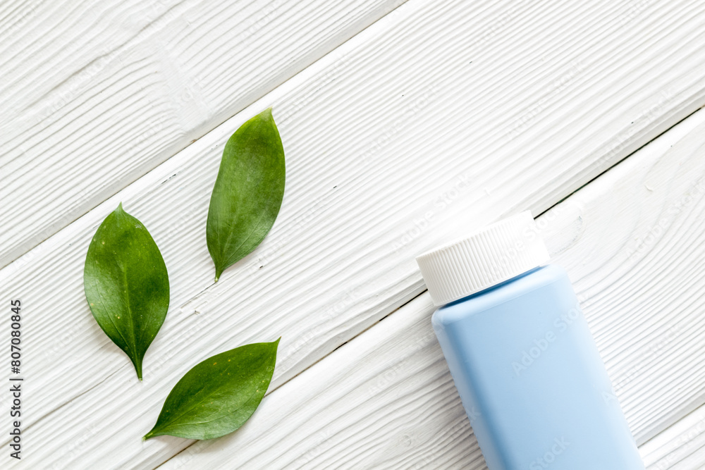Baby talcum powder container with green leaves, top view. Child care ...