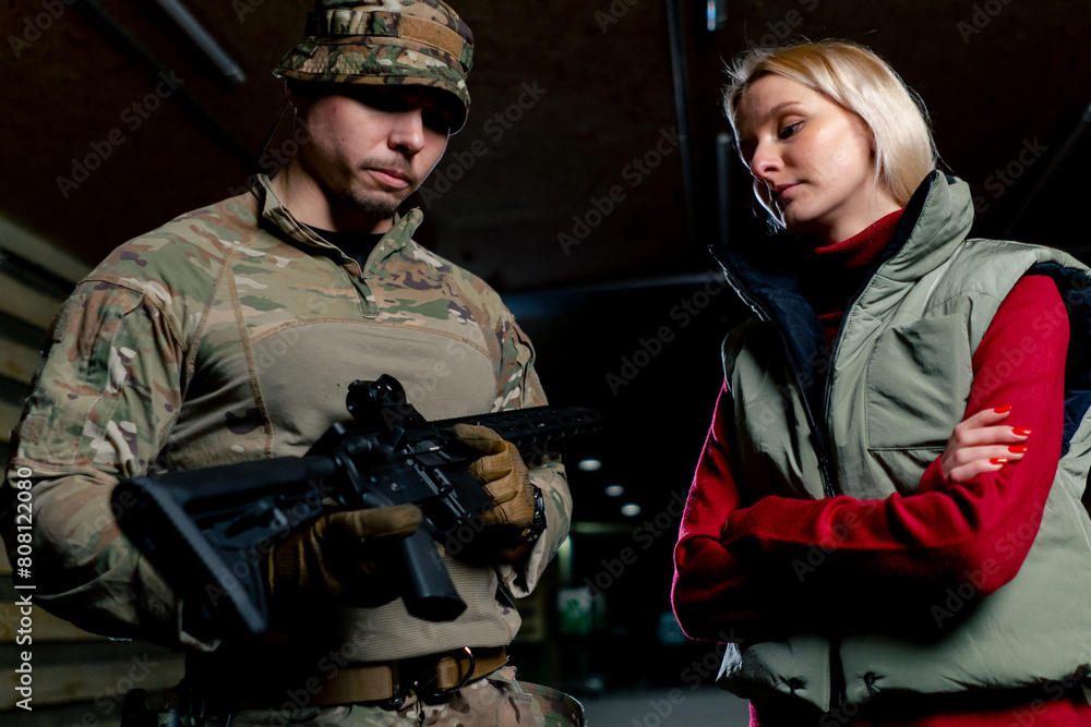 At a professional shooting range military trainer tells a girl how to ...