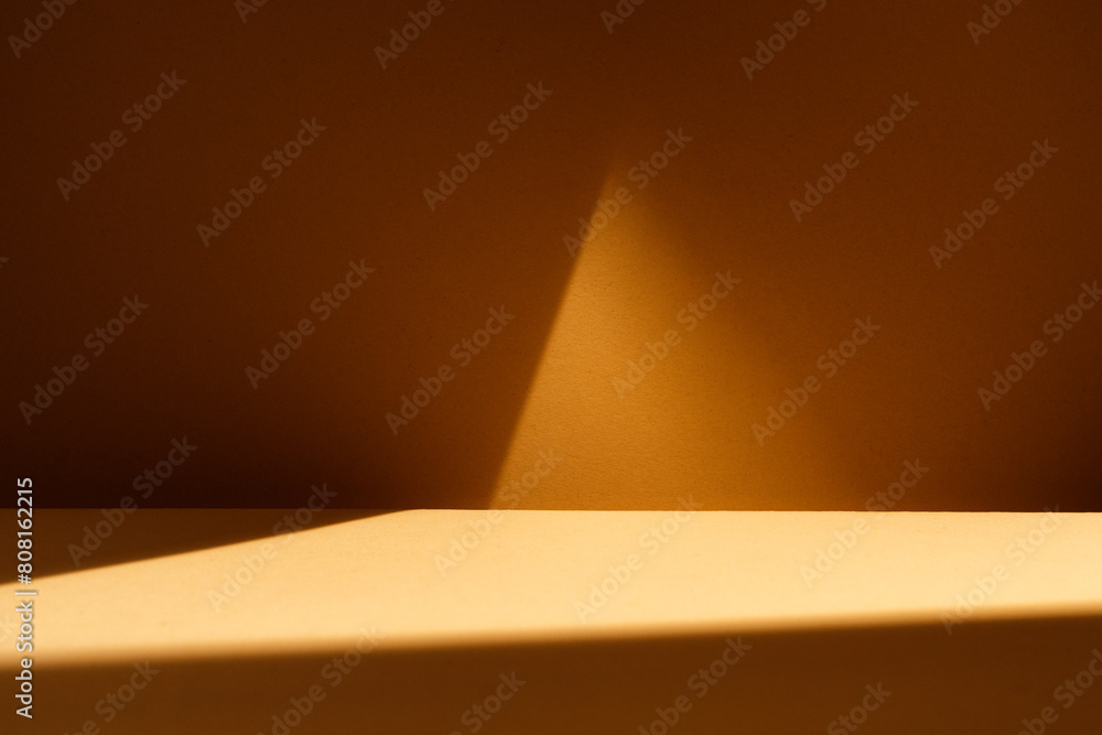 Triangle shadow on brown wall and table. Background with natural shadow ...