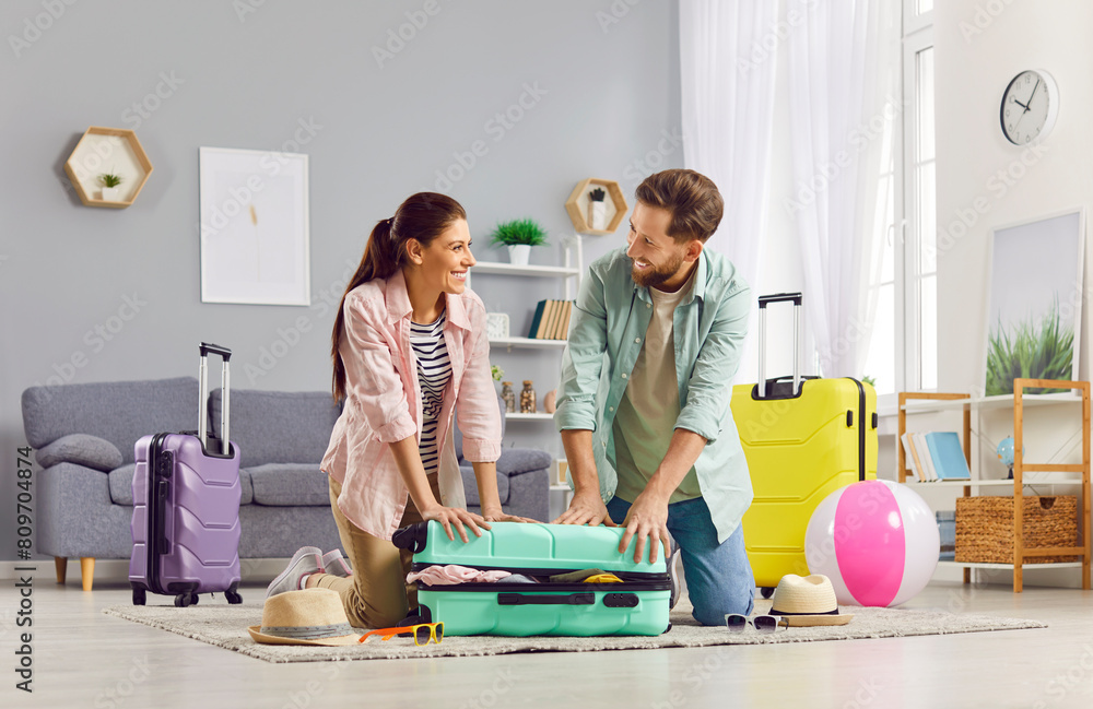 Positive couple getting ready for summer vacation, travel or journey ...