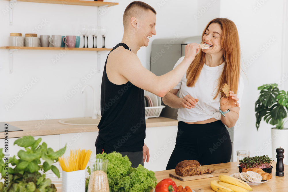 Couple of athletes cooking together healthy food in the kitchen at home ...