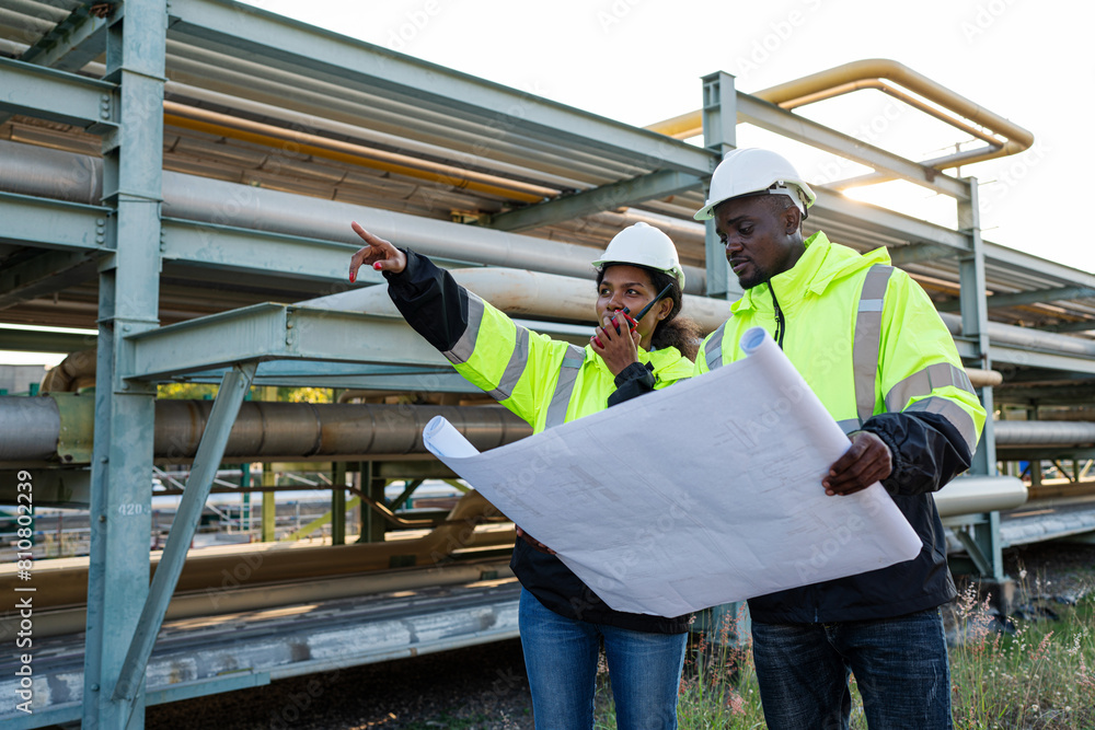 Young mechanical engineer holding blueprint drawing to checking and ...