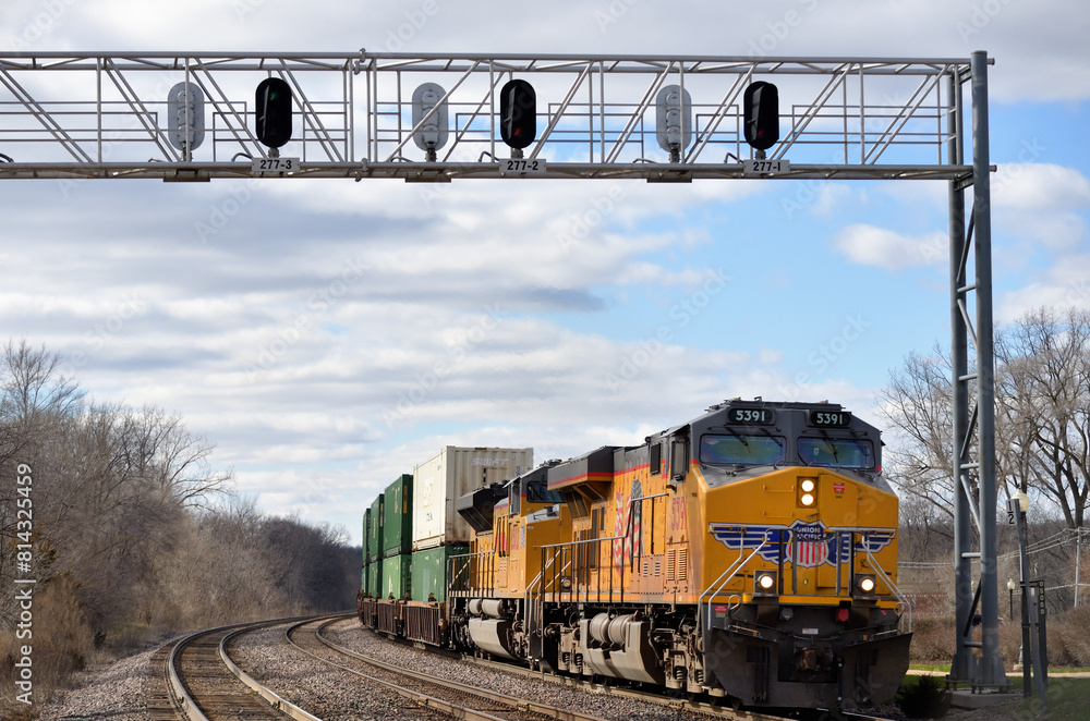 A Union Pacific Railroad intermodal freight train negotiating a curve while passing under a ...