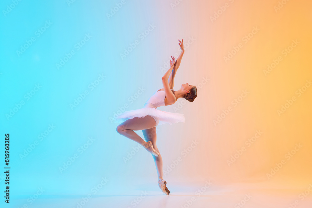 Young ballerina in white tutu dancing and leaning backwards in motion ...