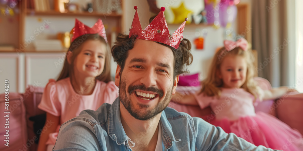 Young cheerful father wearing princess tiara while playing with his two ...