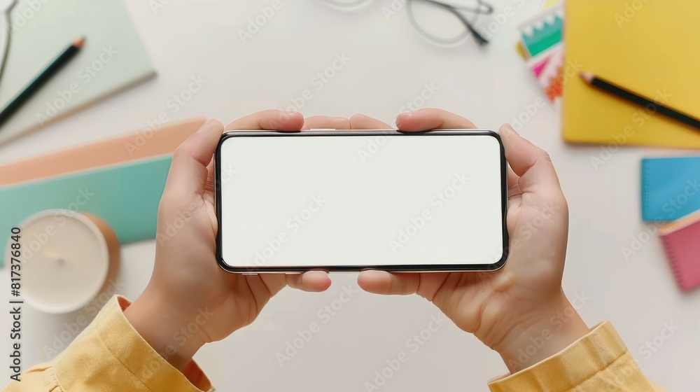Young little boy's hands hold a horizontally oriented phone over a ...