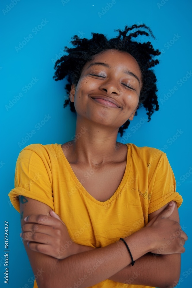 Black woman with fingers crossed and hope in studio, blue background ...