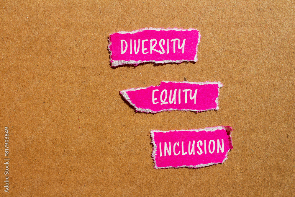 Diversity, equity and inclusion words written on ripped pink paper ...
