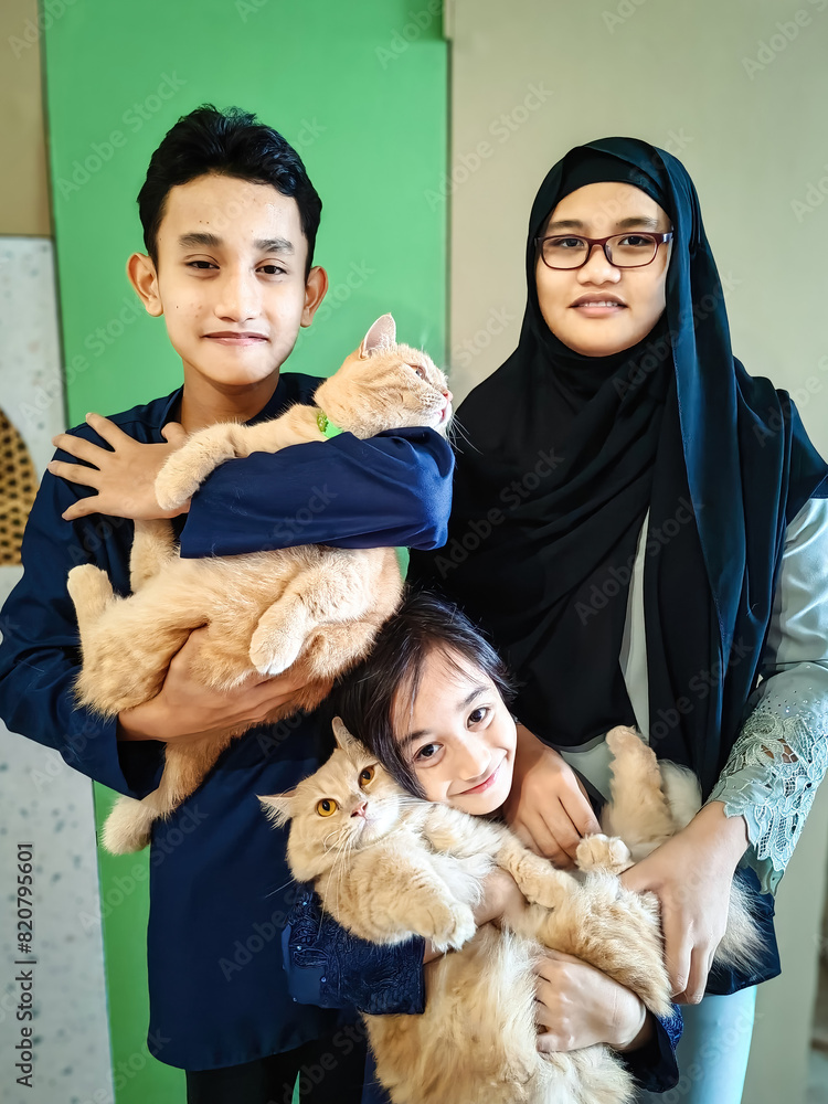 Family and Siblings concept celebrating eid fitr with cats. Asian Malay ...
