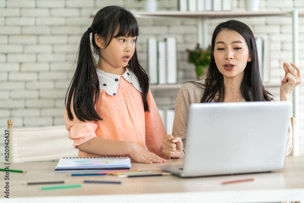 Mother and asian kid little girl learn and look at laptop computer ...