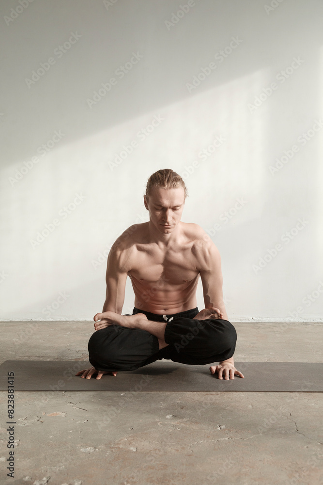 Shirtless fit sportsman performing scale pose in yoga studio の Stock ...