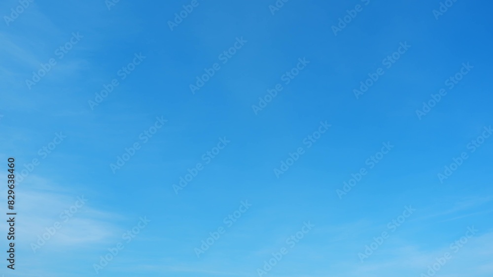 A clear blue sky with very few wispy clouds. The blue color is vibrant ...