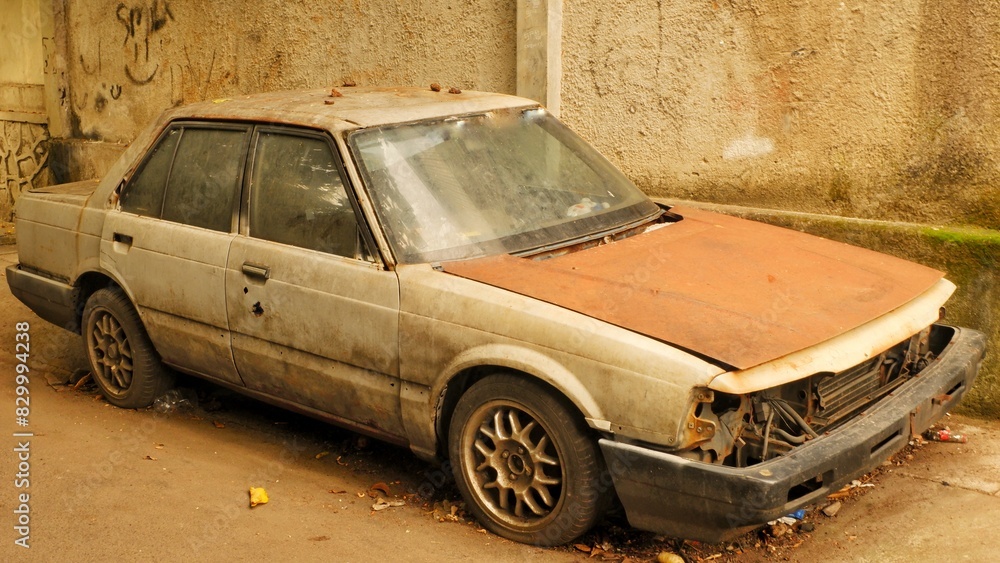 Old classic cars that are damaged and neglected are parked on the side ...
