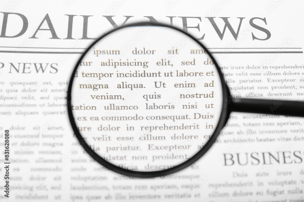 Daily newspaper with magnifying glass, closeup Stock Photo | Adobe Stock
