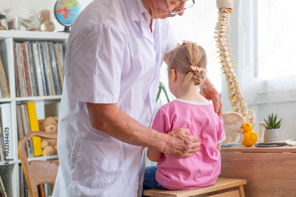 male Orthopedist doctor examining child's back in clinic, physician ...
