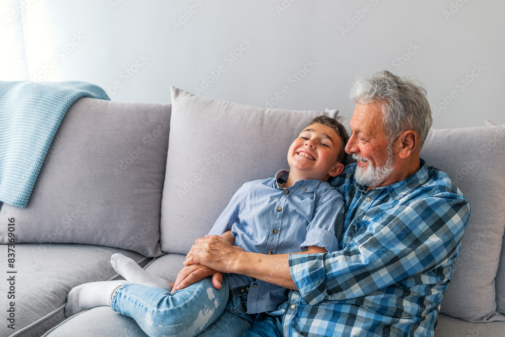 Happy grandfather sit on couch enjoy spending time with preschooler ...
