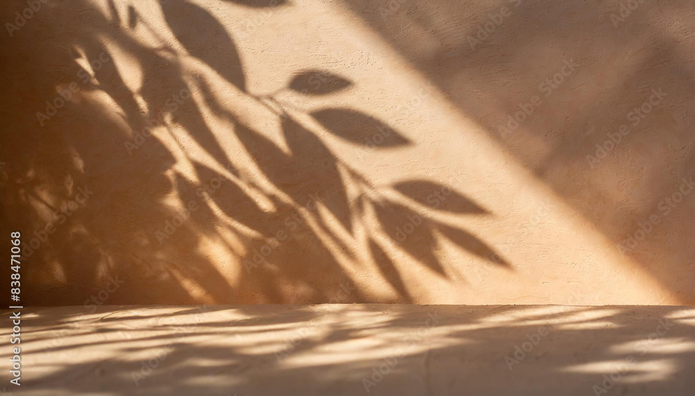 light background of shadows from plant leaves on a light brown beige ...