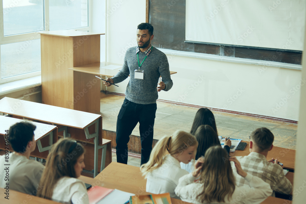 Interactive Learning Session. Young teacher leading lecture in front of ...