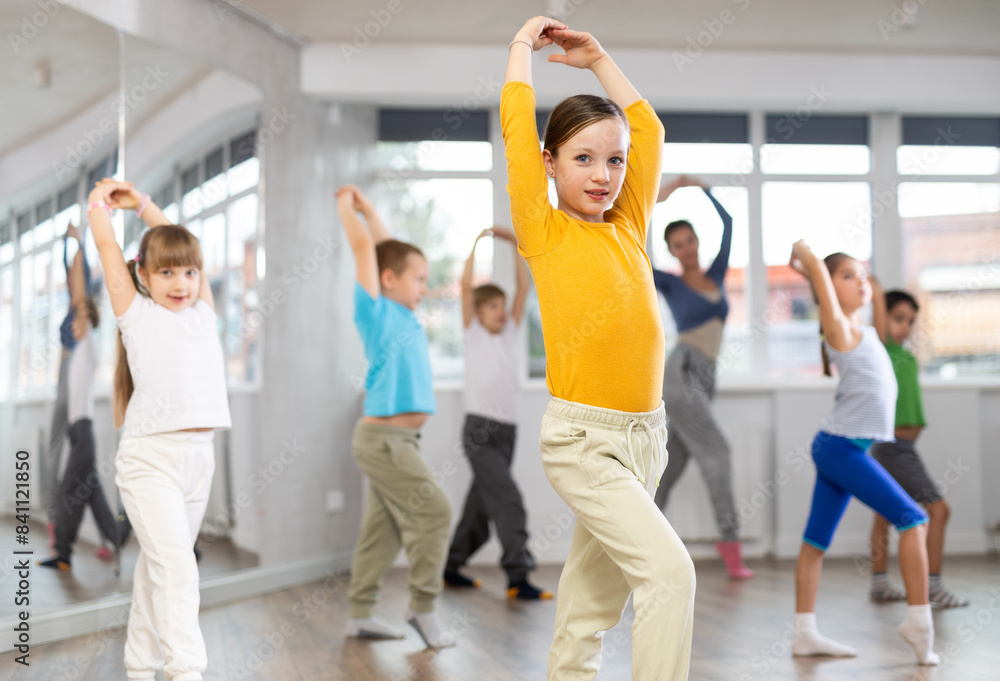 Dynamic little girl training hip hop dance poses with instructor and ...