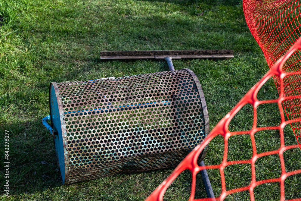 Old metal blue drum roller and rake, grass pasture invasive plant ...