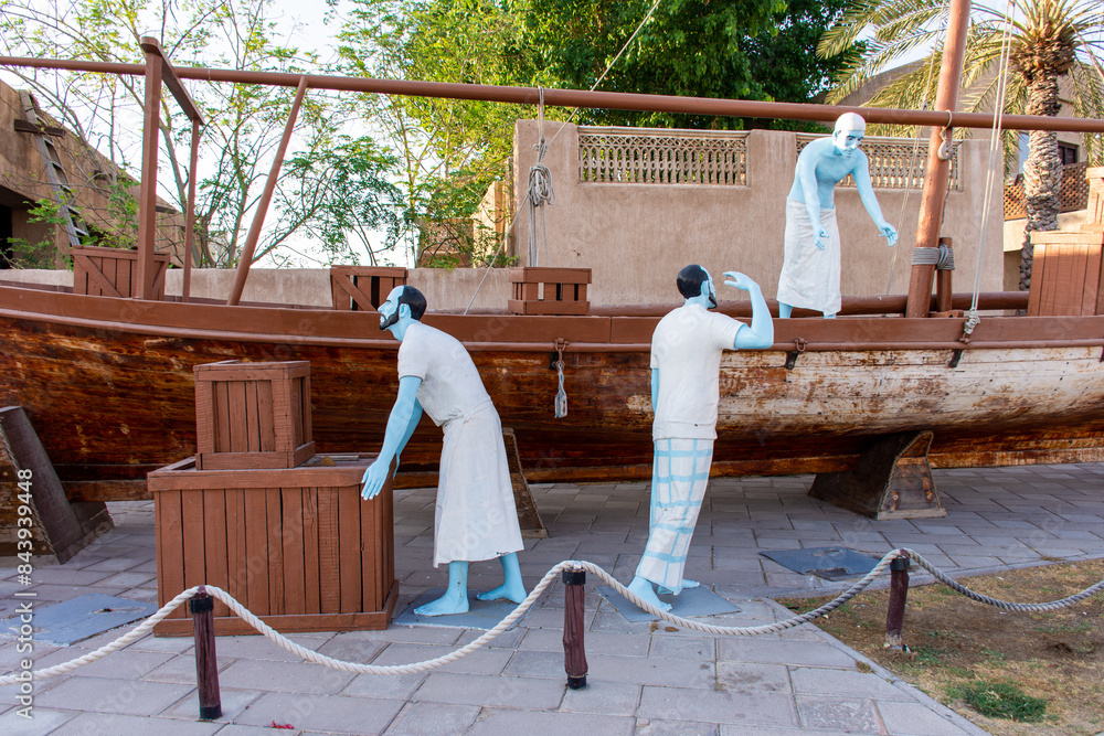 Statue of workers in traditional pearl diving boats in a heritage ...