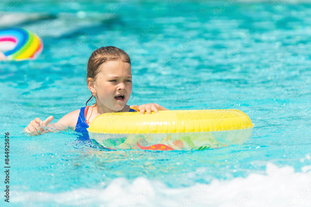 Beautiful cute little girl swims in the outdoor pool with an inflatable ring Stock Photo | Adobe ...