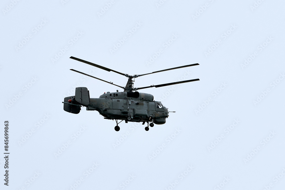 Russian military helicopter armed with missiles flies in blue sky ...