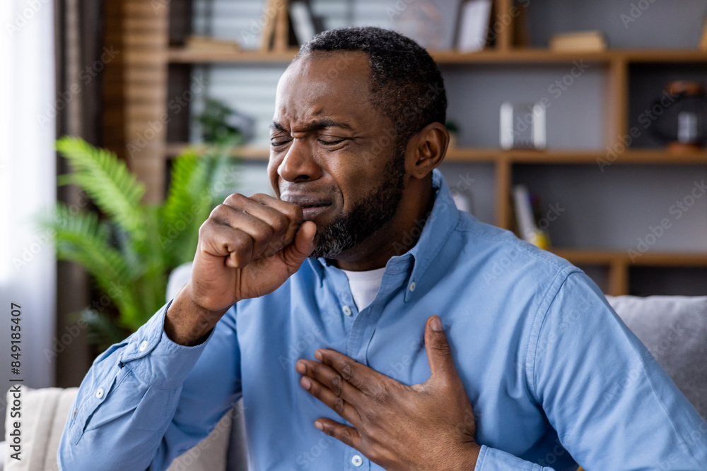 Man clutching chest and coughing, depicting symptoms of illness or ...