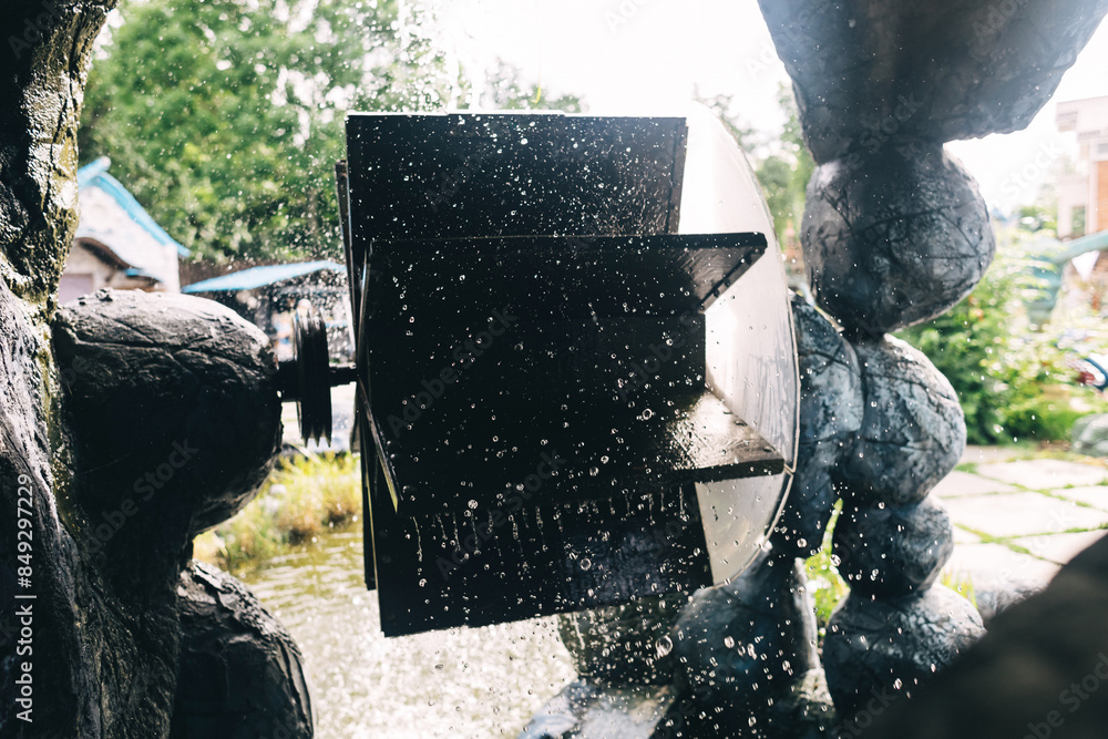 Water wheel in the park. A mechanism with a rotating motion that ...