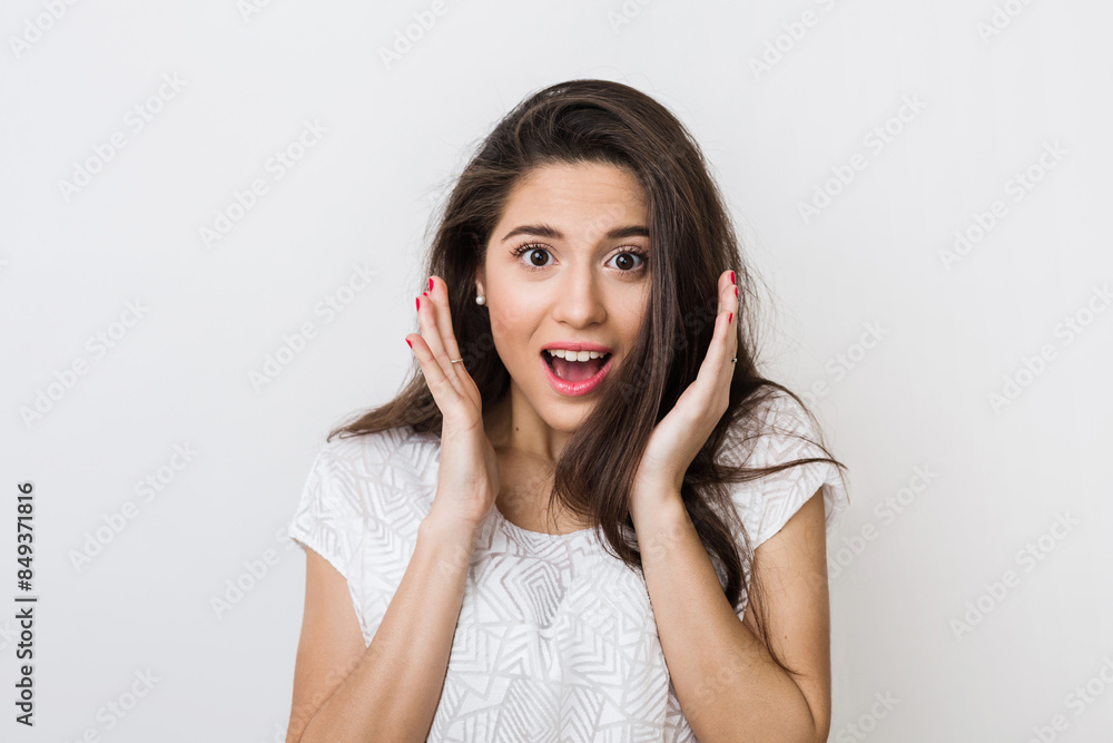 portrait of young surprised woman in white blouse with long hair ...