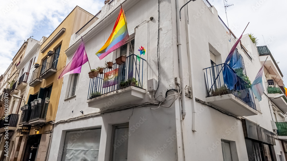 Colorful pride flags waving on urban apartment balconies, symbolizing ...