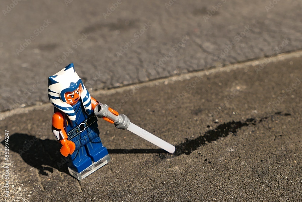 LEGO Star Wars figure of Ahsoka Tano drawing a black line on asphalt ...