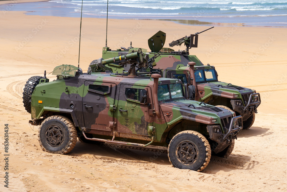 Military armored vehicles on the sandy seashore, which is equipped with ...