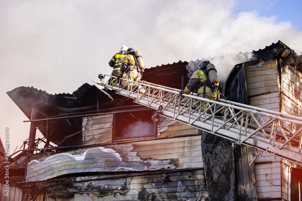 Fireman team extinguishes burn with hose water from ladder of aerial ...
