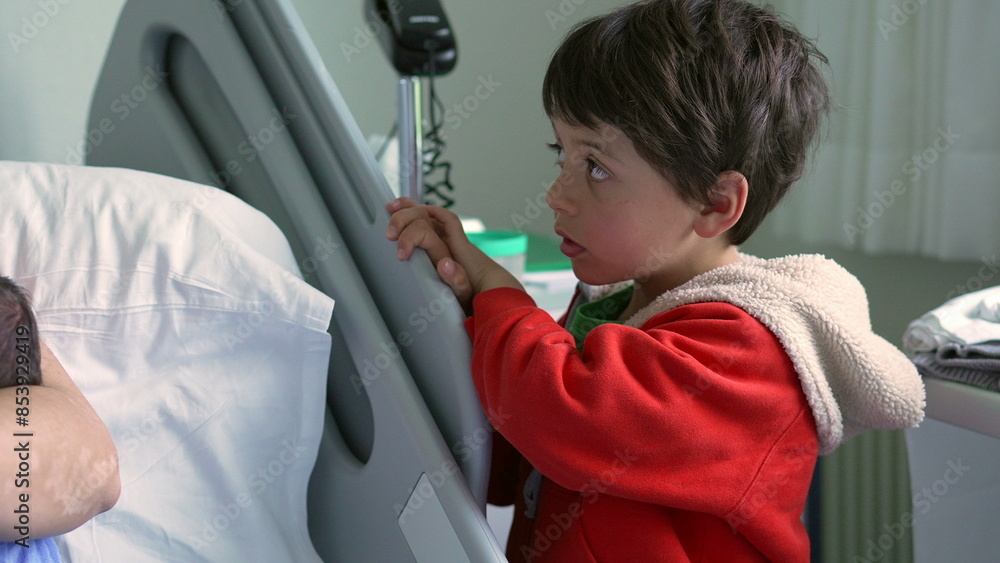 Big brother leaning on hospital bed, watching mother in pain, capturing ...