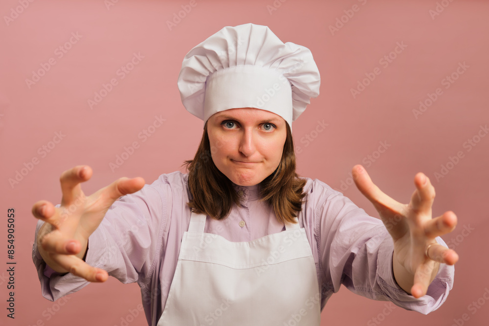 Woman cook stretching her arms on studio pink background. Portrait of a ...