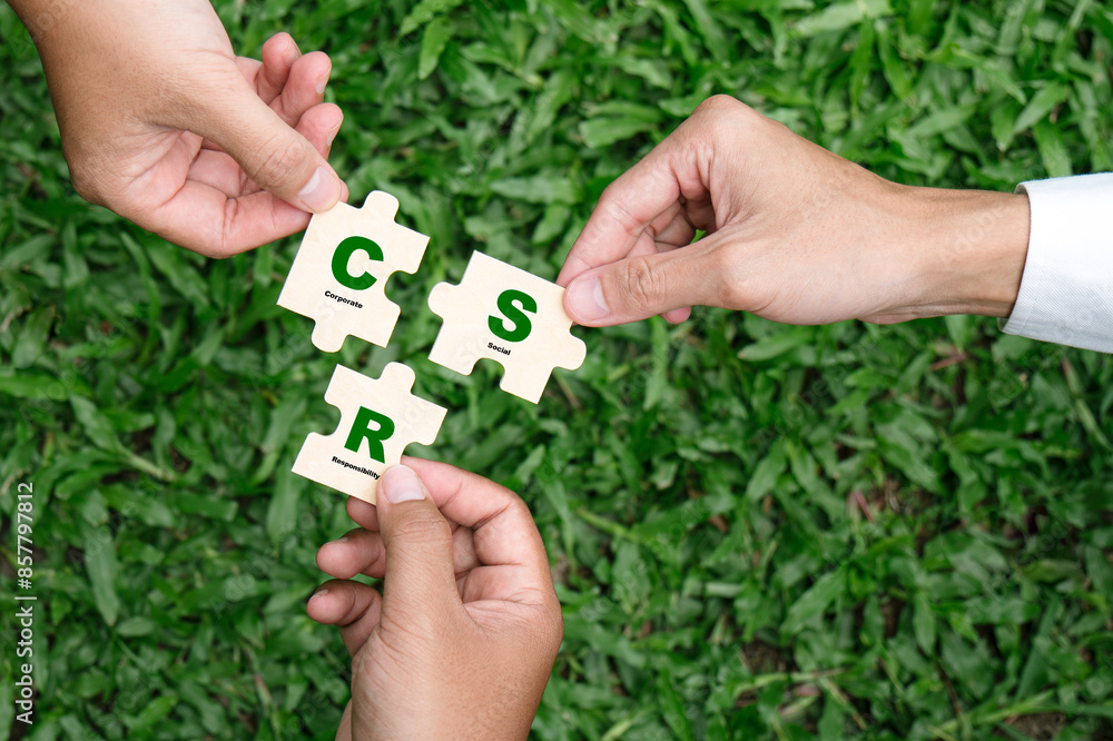 Businessman hands holding puzzle with CSR word together on blur green ...