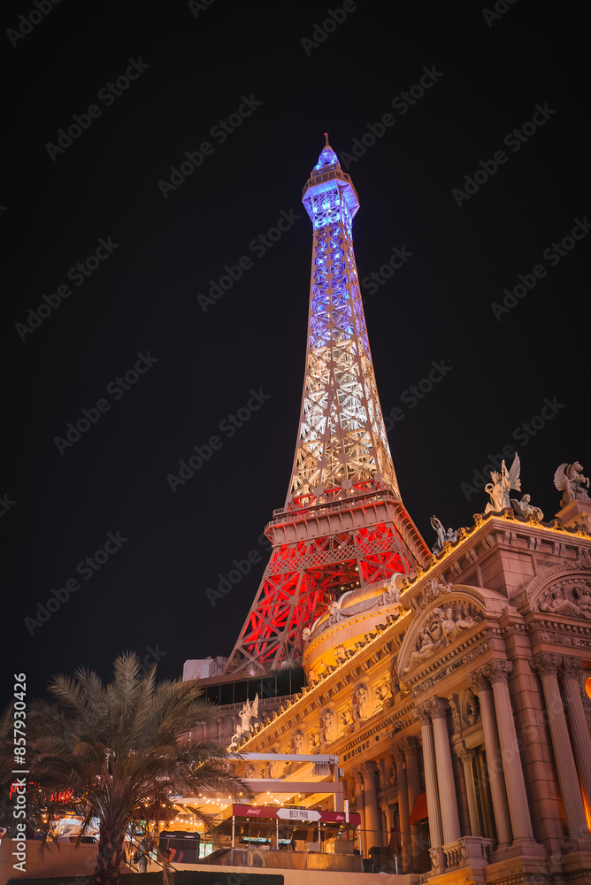 Night view of iconic Las Vegas attraction, a replica Eiffel Tower illuminated in blue and red ...