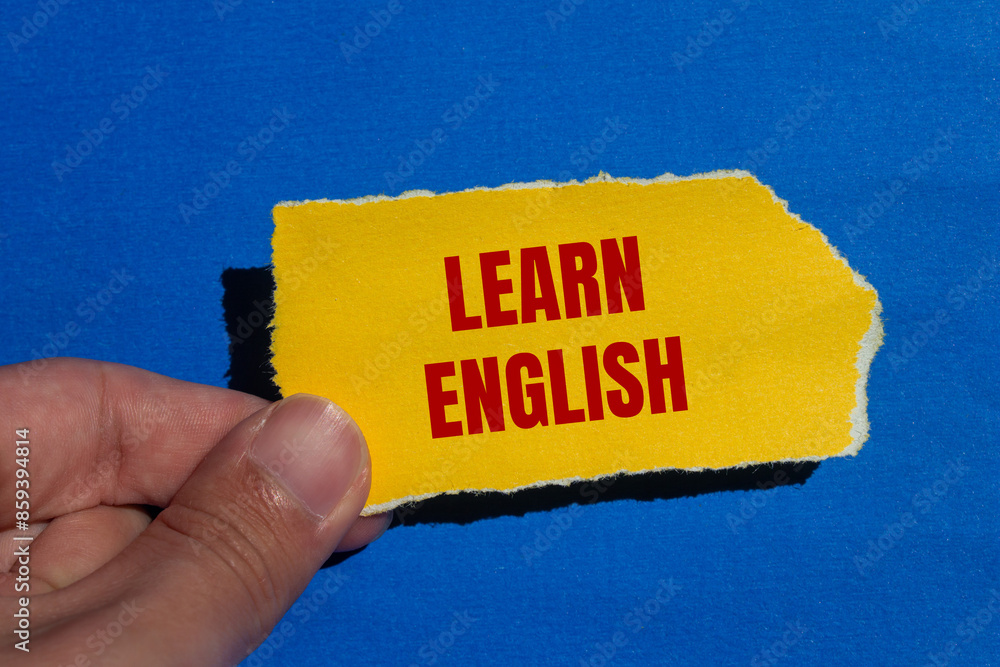 Learn english message written on ripped torn yellow paper with blue ...