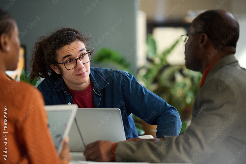 Portrait of gen Z young man collaborating with senior colleague in ...