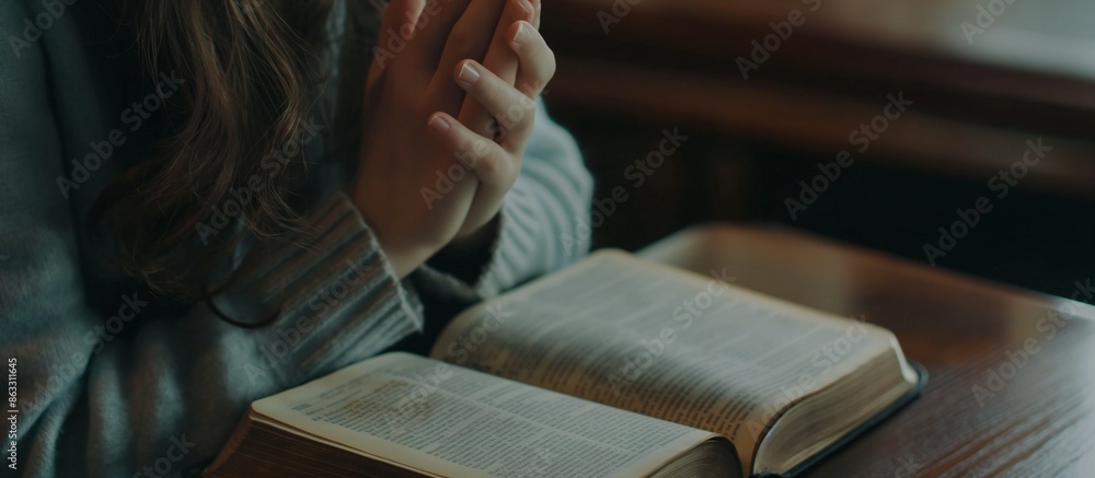 Person reading book praying with Bible. A man praying in front of Bible ...