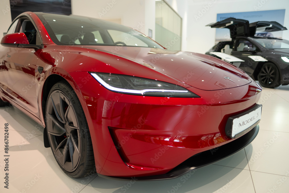 new red Tesla Model 3 electric car in showroom, trends in use EV in ...