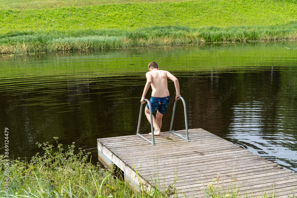 Young man guy going to swim in the lake. Special wooden pier is ...